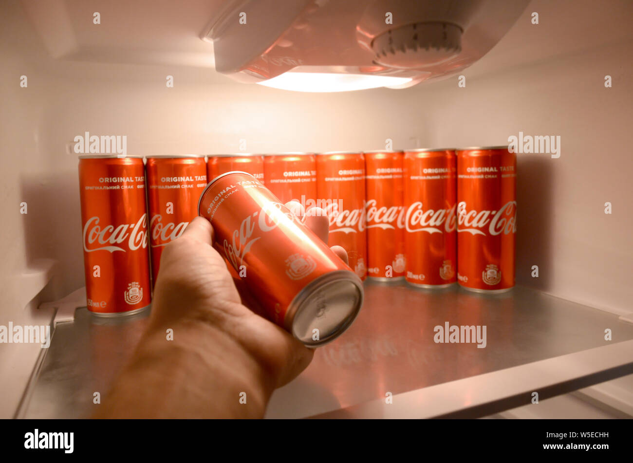KHARKIV, UKRAINE - JULY 15, 2019: Male hand shows Coca-cola red drink ...