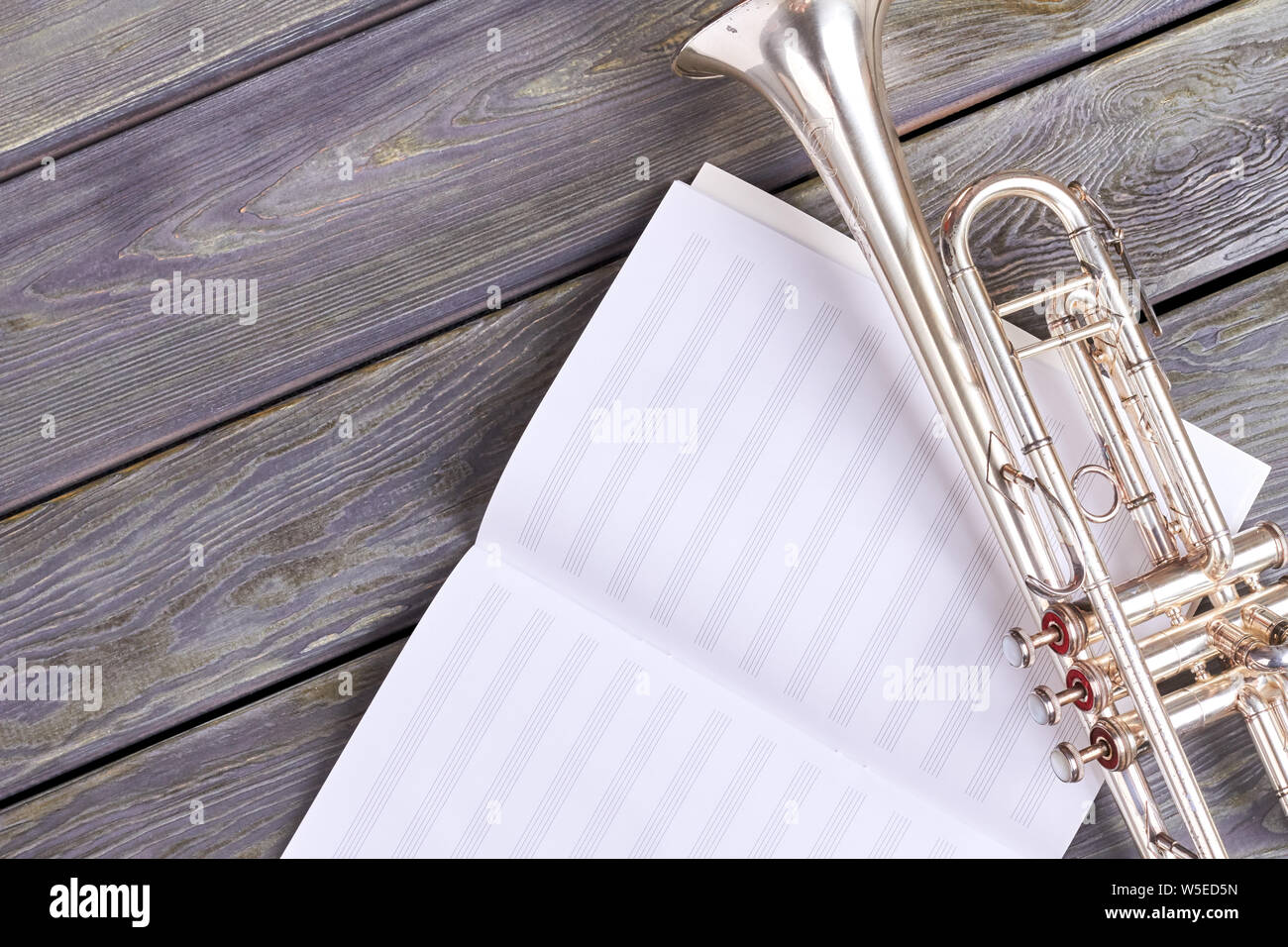 Old trumpet on musical notes sheet Stock Photo - Alamy