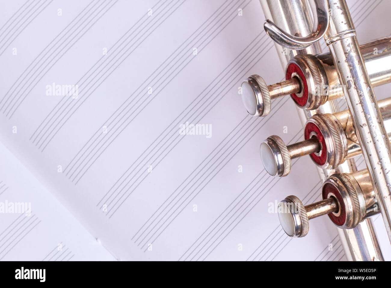 Old trumpet on musical notes sheet Stock Photo - Alamy
