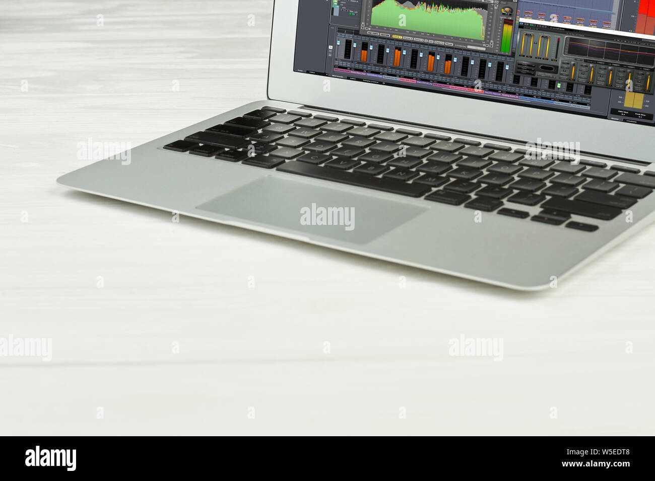 Silver laptop on white surface Stock Photo - Alamy