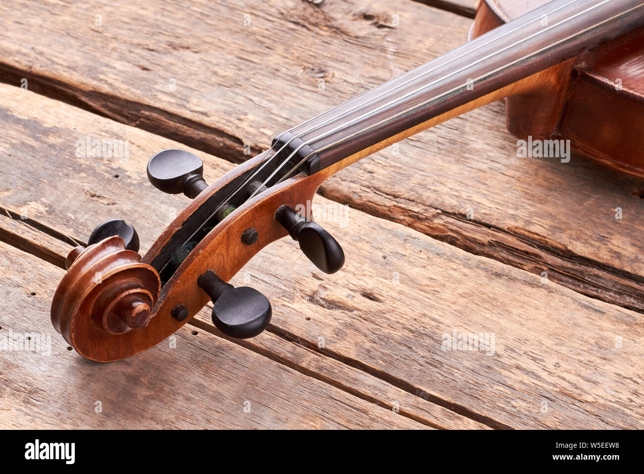 Scroll of the old violin on wooden floor Stock Photo - Alamy
