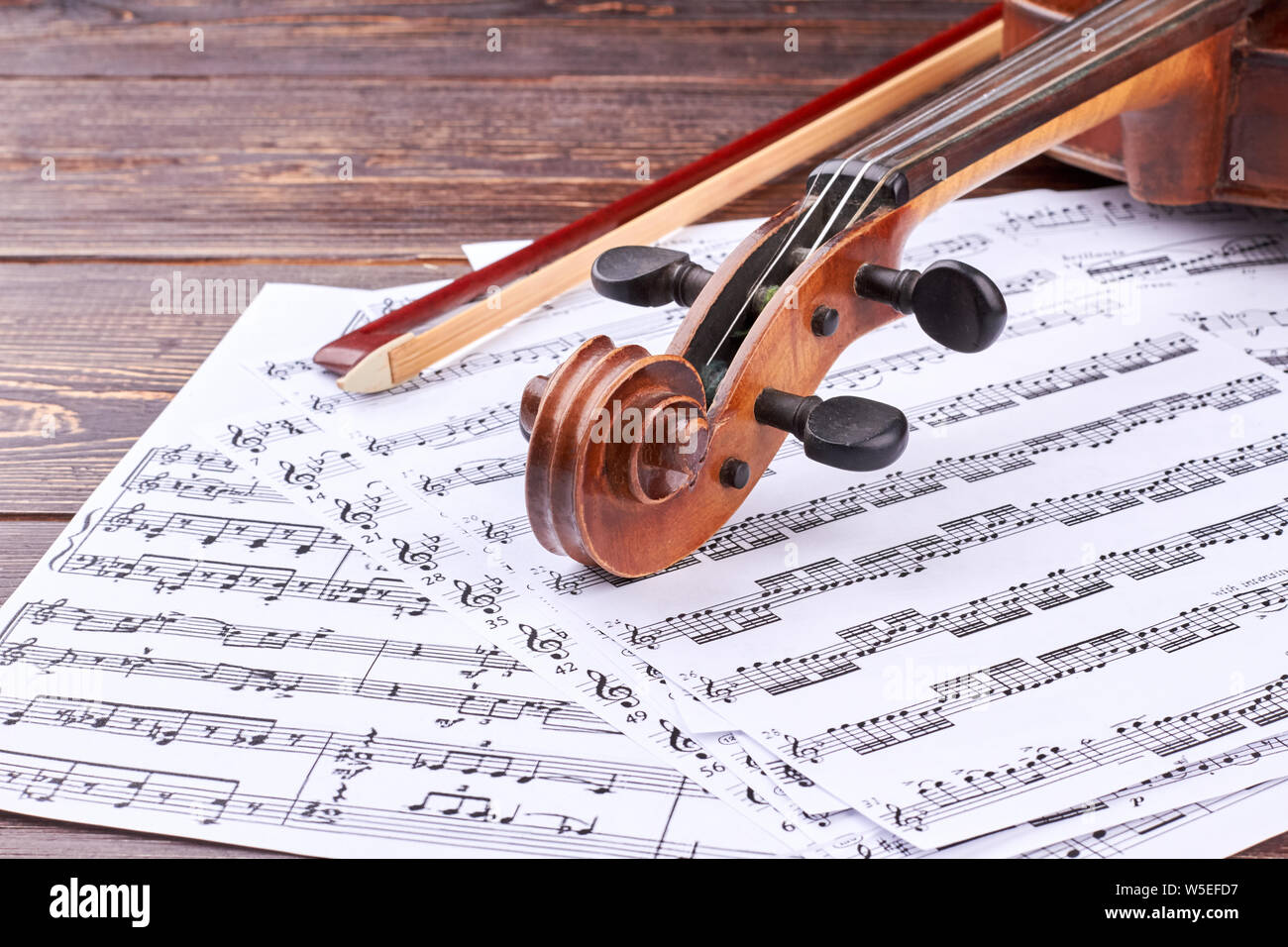 Violin scroll and peg box on musical notes Stock Photo - Alamy