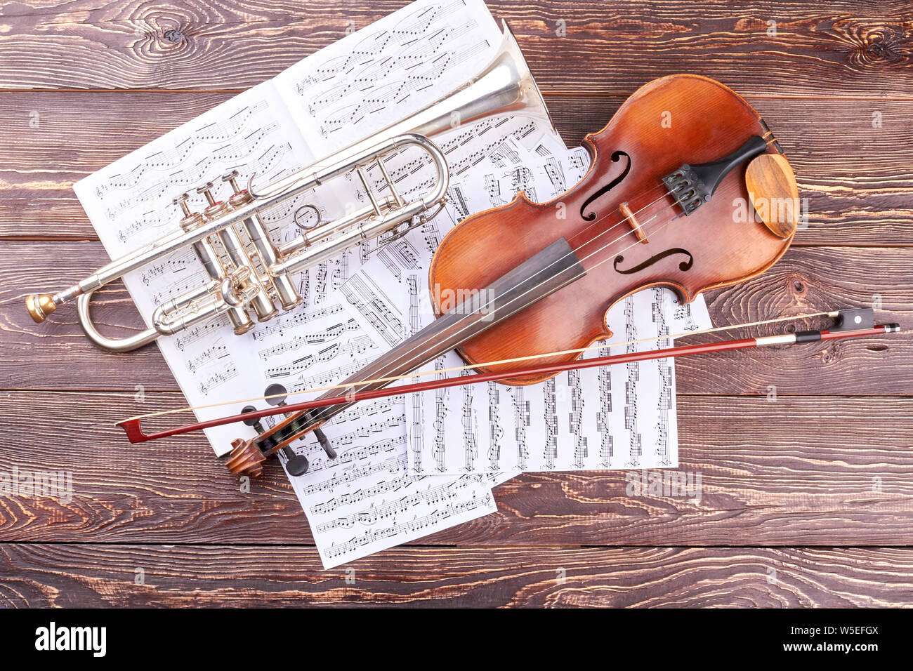 Trumpet and violin on wooden background Stock Photo - Alamy