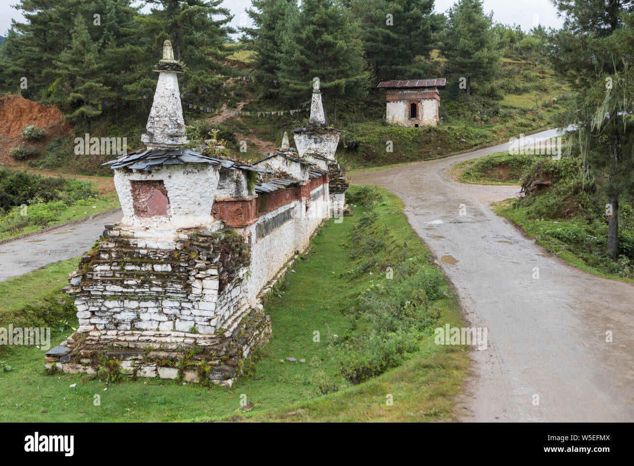 A Buddhist prayer wall and chorten or stupa at the bottom of the road ...
