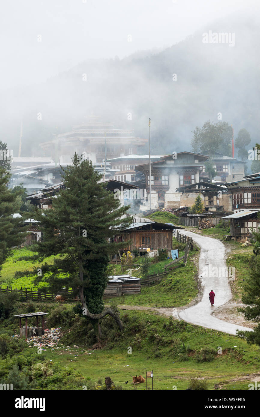 A monk walks up the road to the village and Gangtey Monastery in the ...