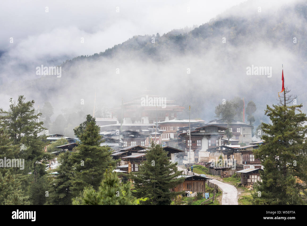 Two men walk up the road through the village to the Gangtey Monastery ...