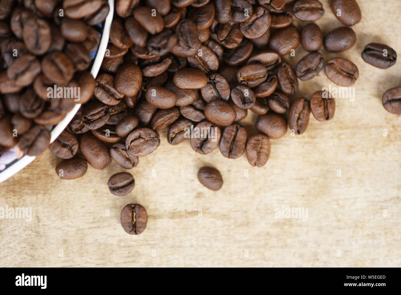 Coffee beans roasted on rustic wood background Stock Photo - Alamy