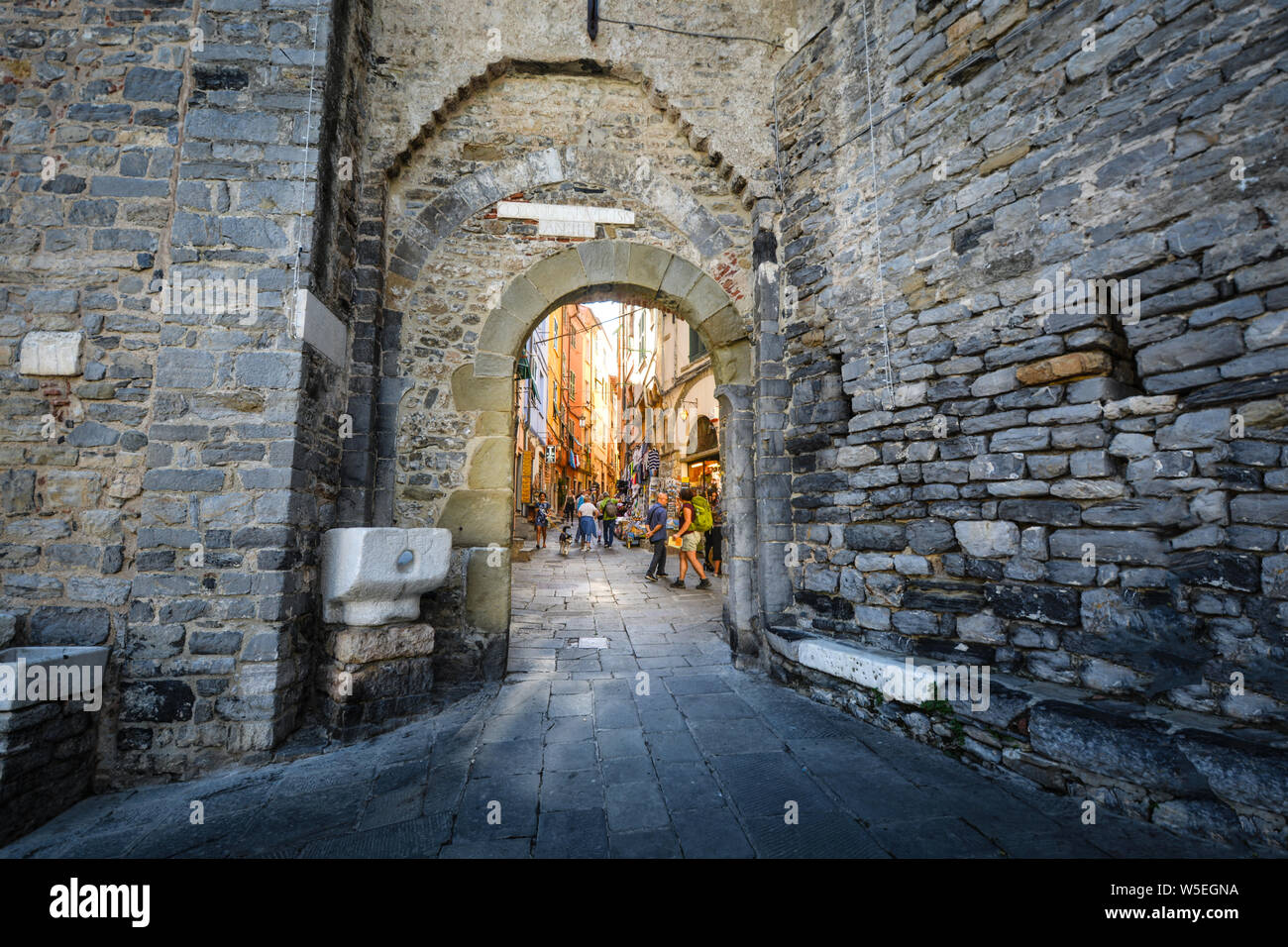Tourists sight-see and shop inside the ancient town gate of the coastal ...