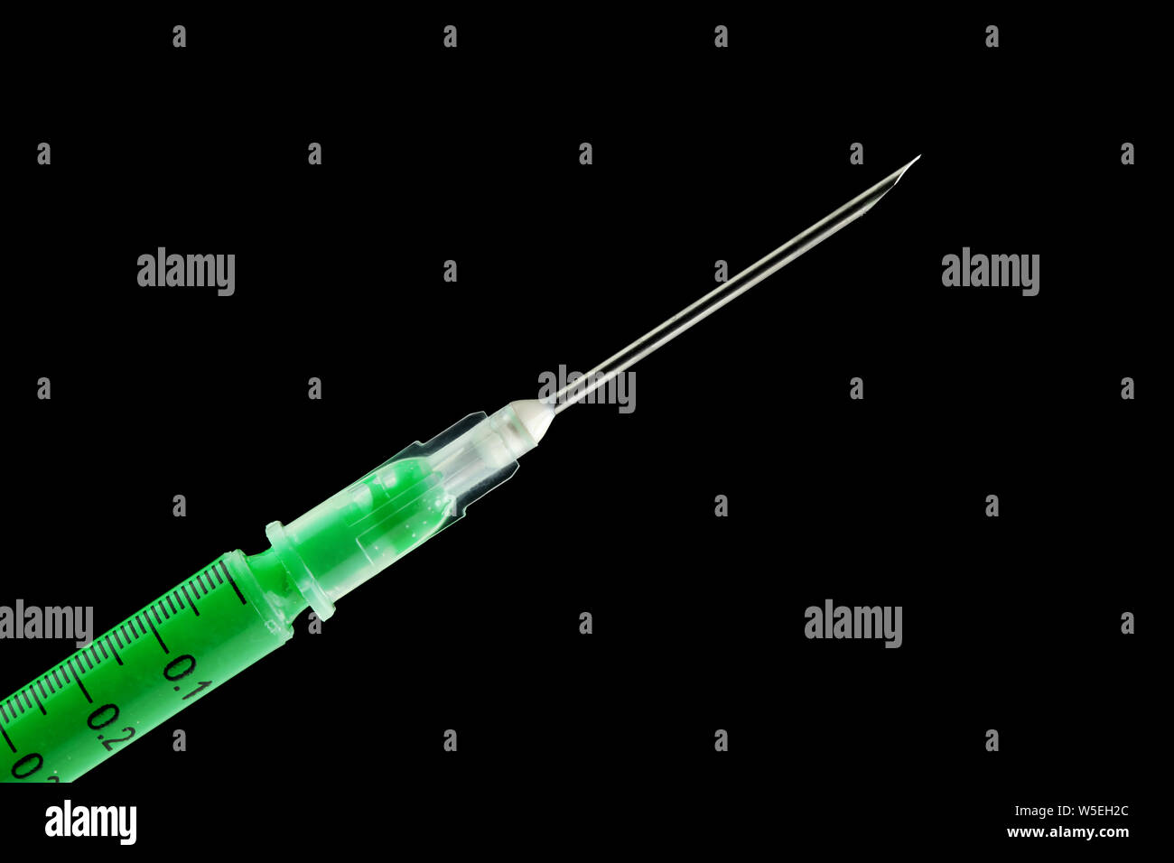 Syringe filled with green drug and dripping from the needle - isolated ...
