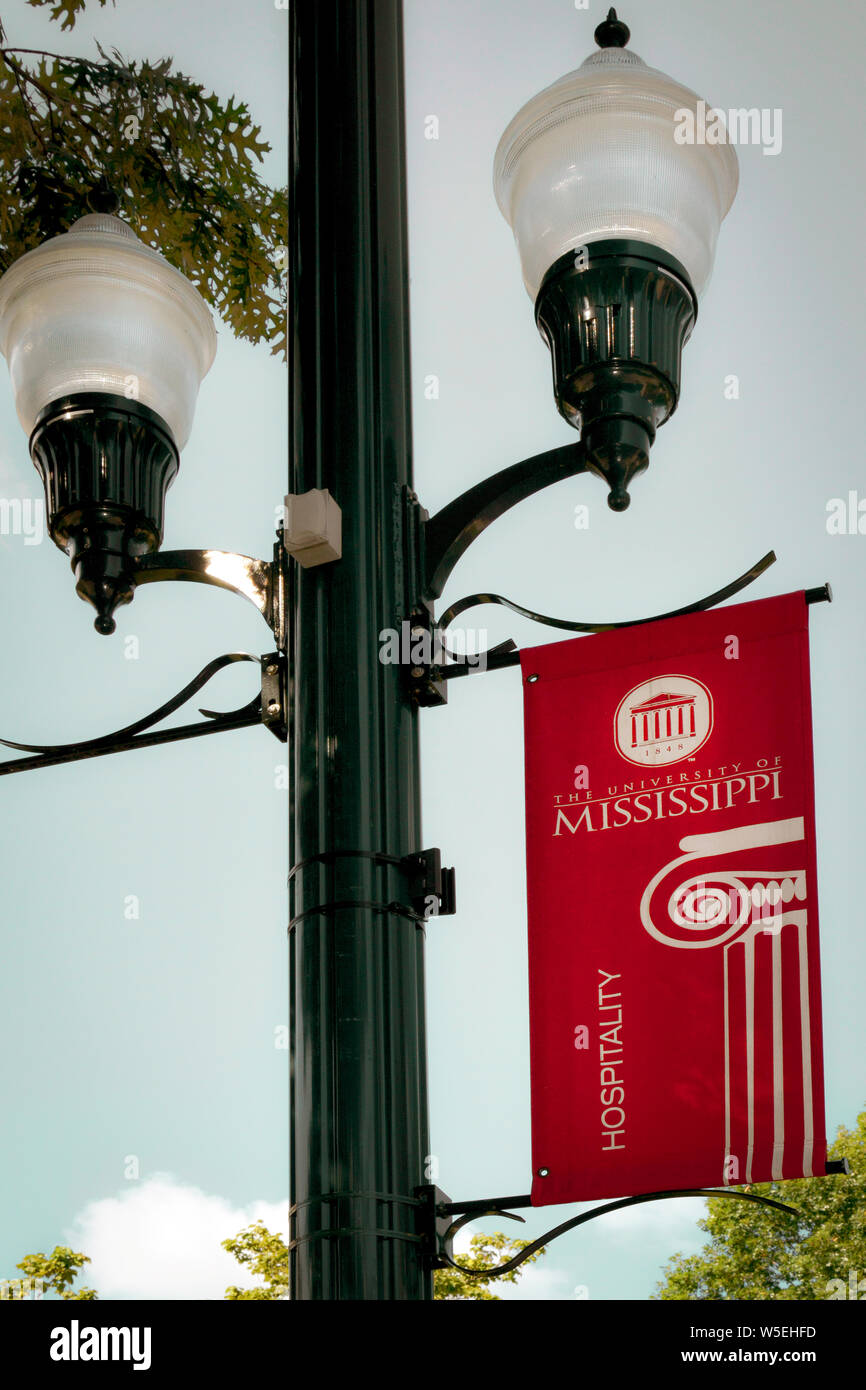 A red University of Mississippi banner hangs from a vintage lamp post ...