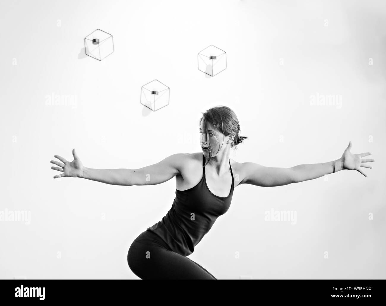 A young white brunette woman doing yoga poses against a white ...