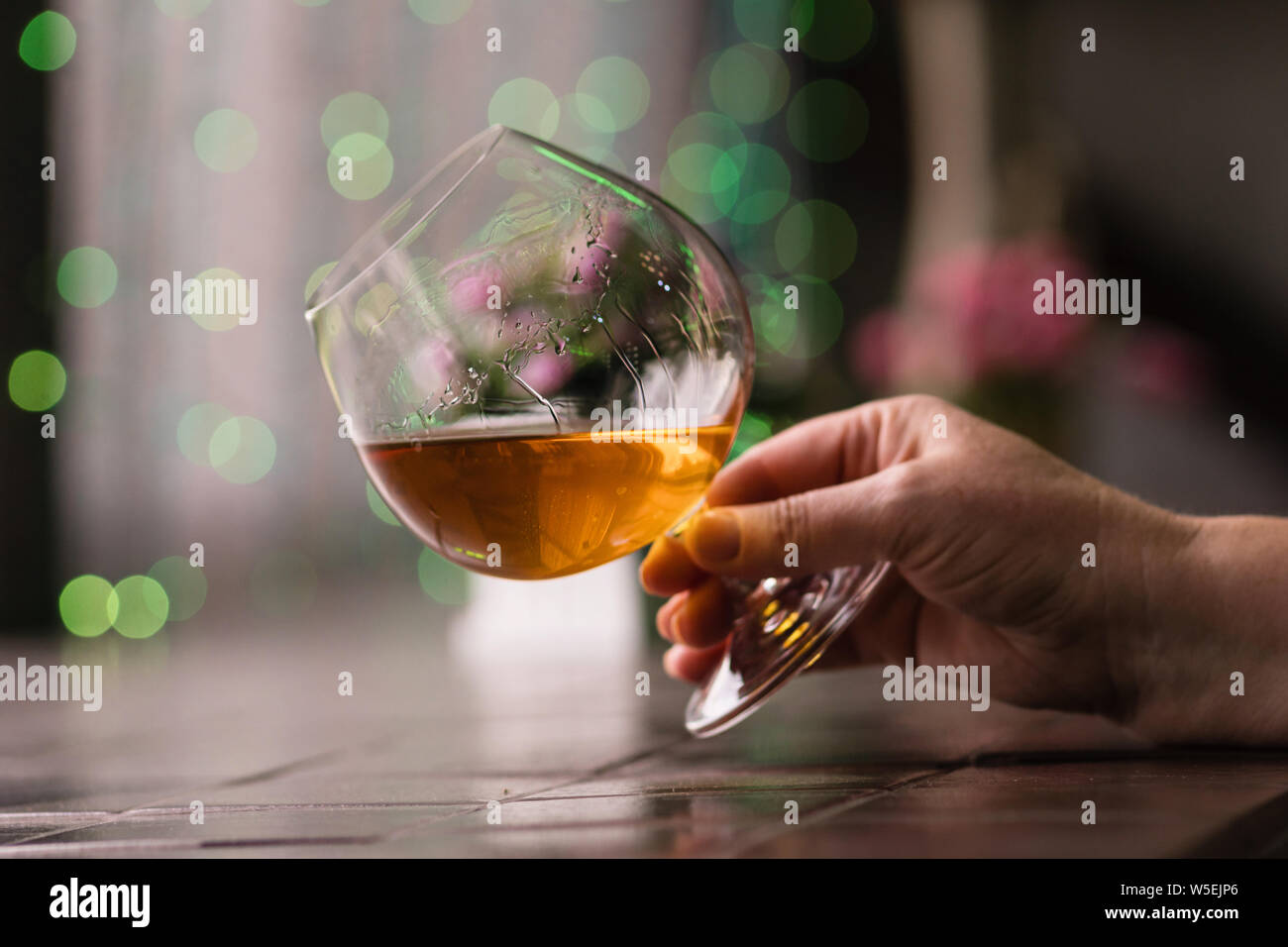 Female hand holding glass of cognac. Relaxation concept. Snifter of ...