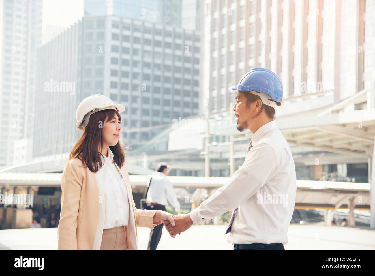 Smart beautiful engineer shaking hands with handsome foreman ...