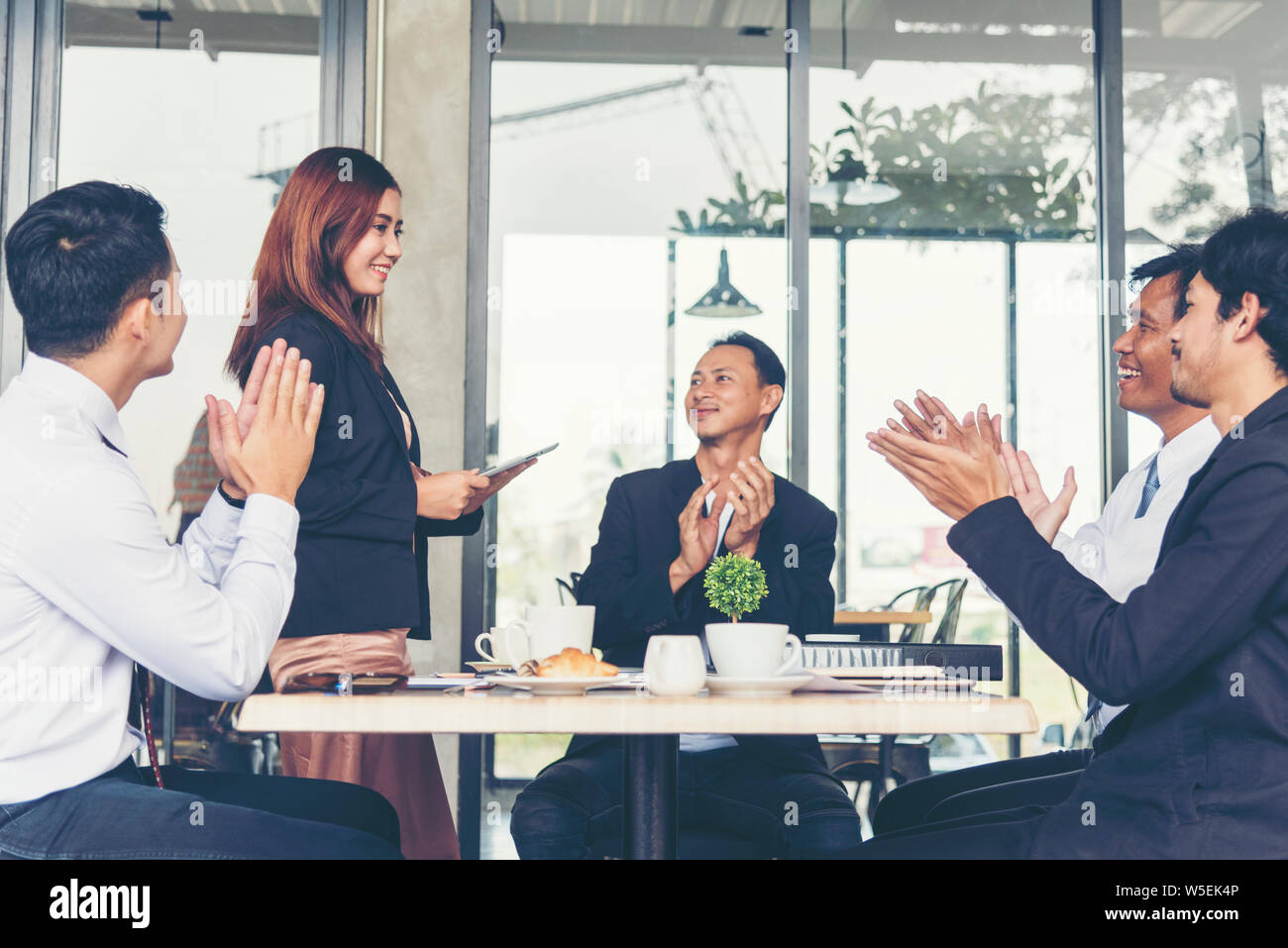Business Partners clapping hands to a success business woman after ...