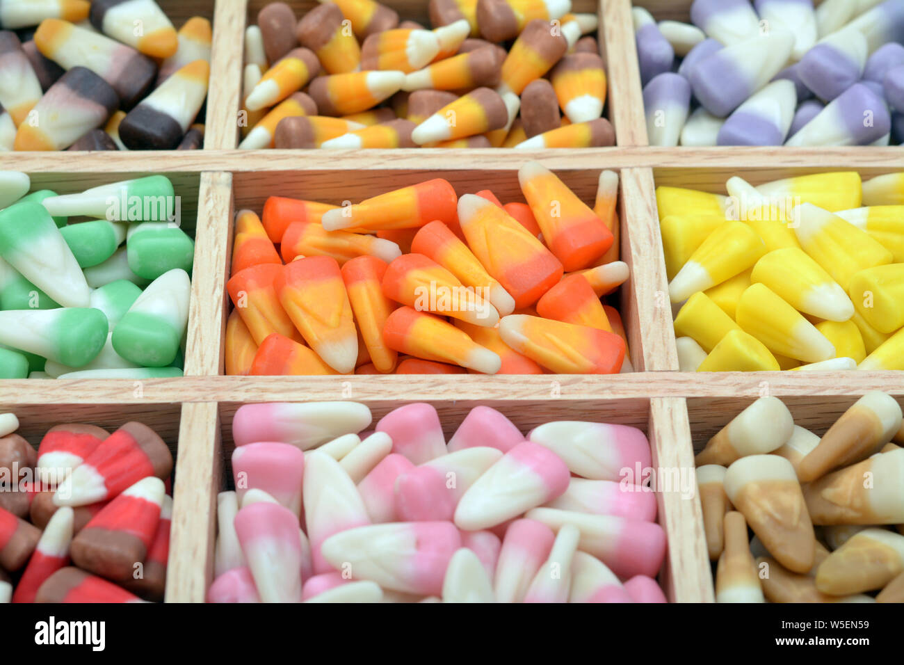 a lot of tooth corn candies in wooden case for background Stock Photo ...
