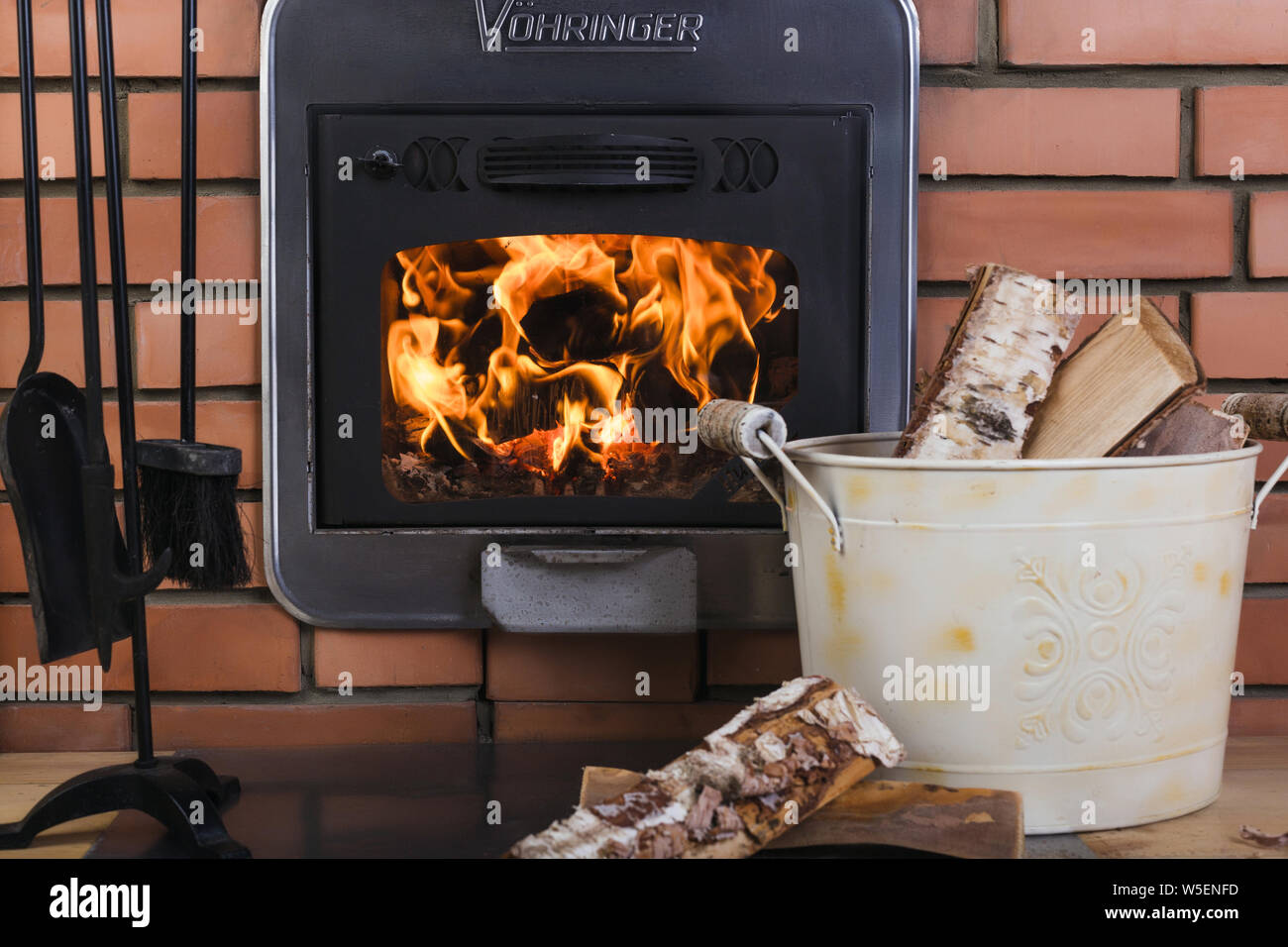 Comfort interior with closed burning fireplace. Composition, firewood ...