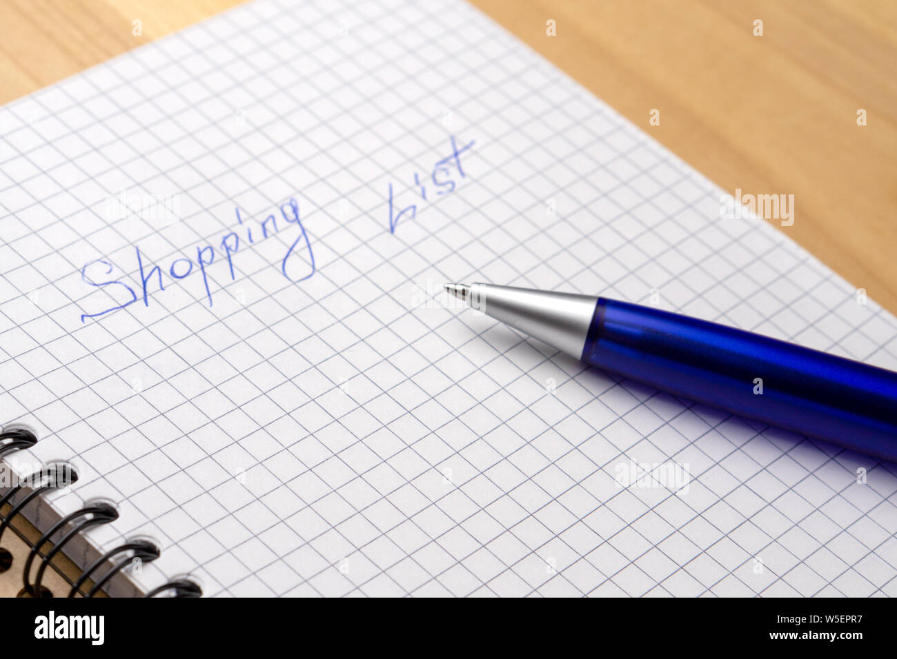 Blue pen on a notebook with sheets in a cage. Sign Shopping List. Close ...