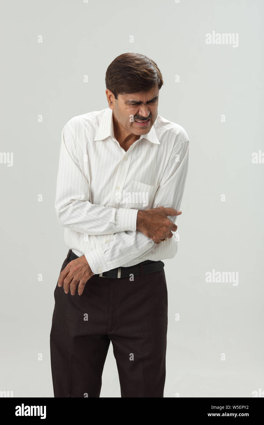 Indian businessman suffering from arm pain Stock Photo - Alamy