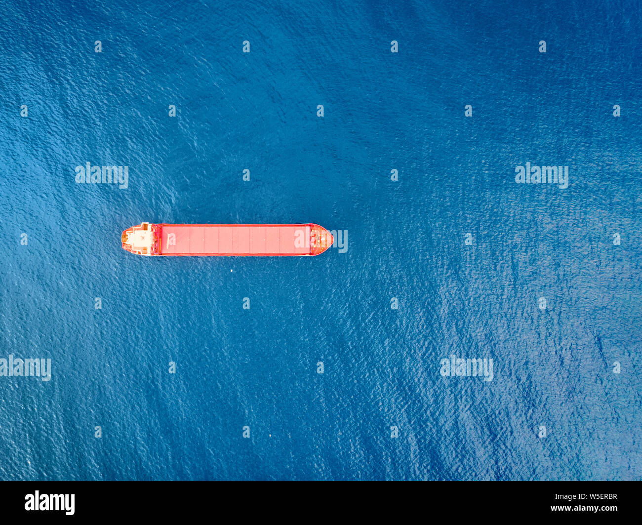 Red color container ship at sea shot from above. Scenic waterscape and ...