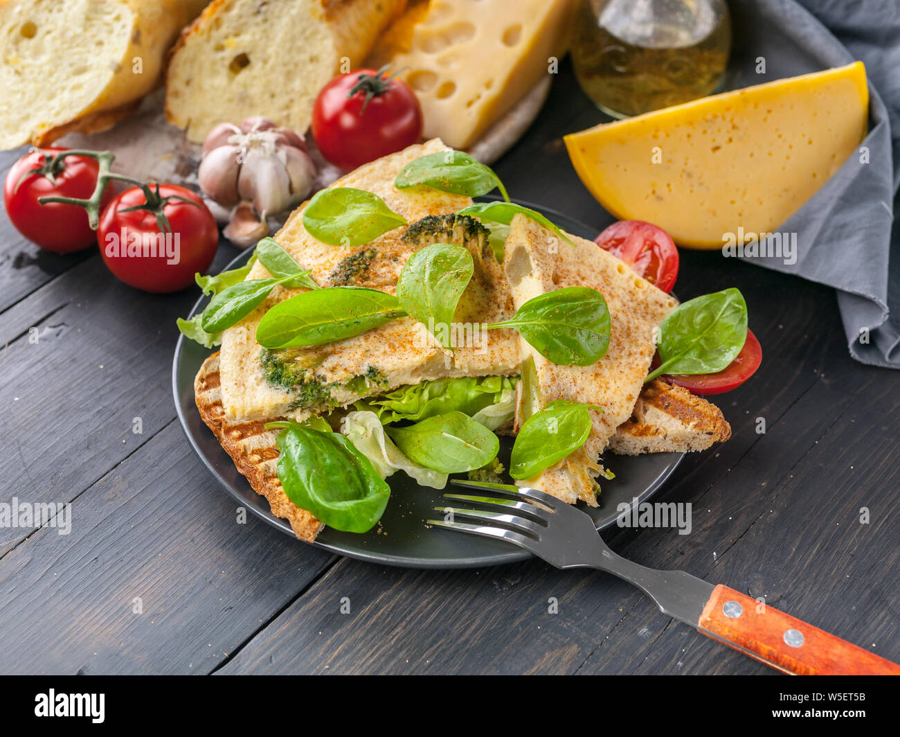 Close-Up Omelette with vegetables, cheese and spinach leaves on toast ...