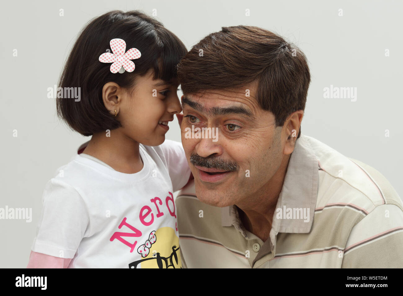 Girl whispering into her grandfather,s ear Stock Photo - Alamy