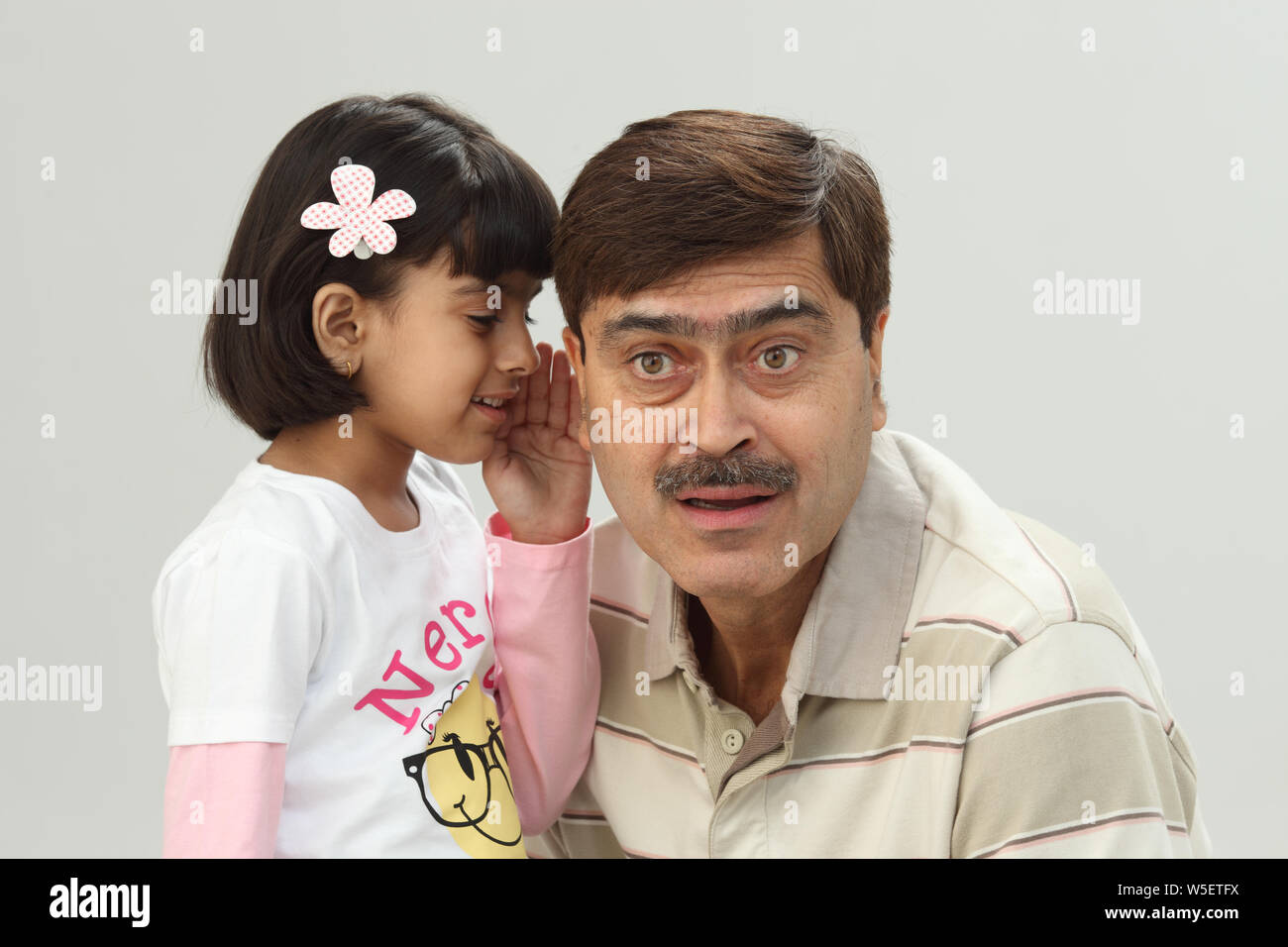 Girl whispering into her grandfather,s ear Stock Photo - Alamy