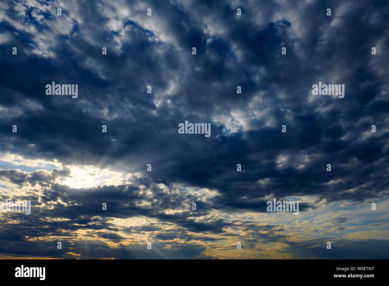 Beautiful sunset - dark sky with clouds and sunlight Stock Photo - Alamy