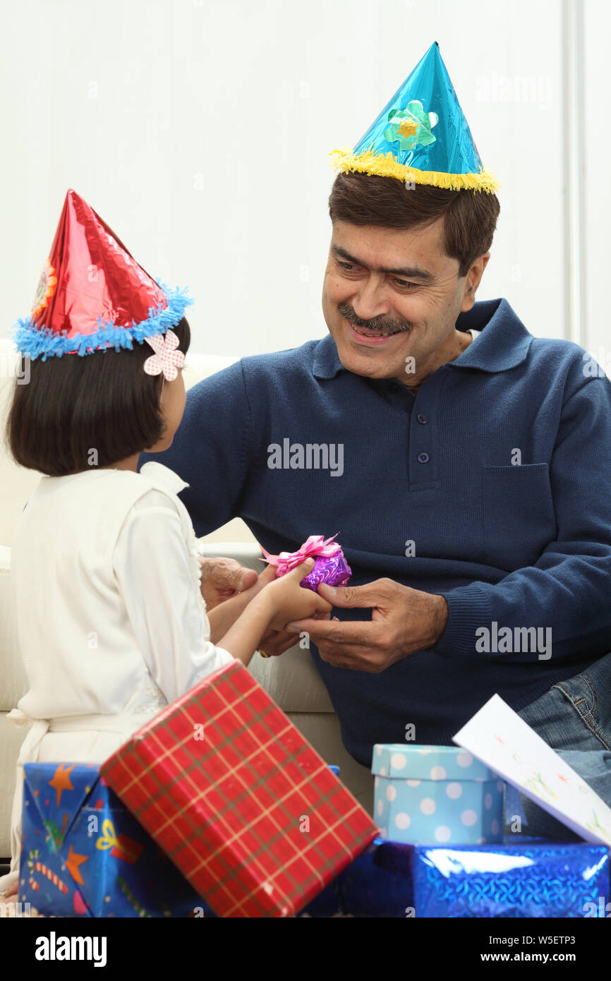 Girl giving gift to his grandfather Stock Photo - Alamy