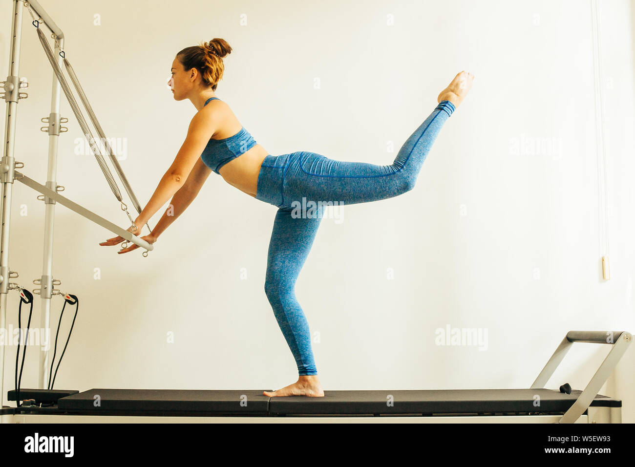 Pilates front Splits on the Reformer inside a modern studio Stock Photo ...