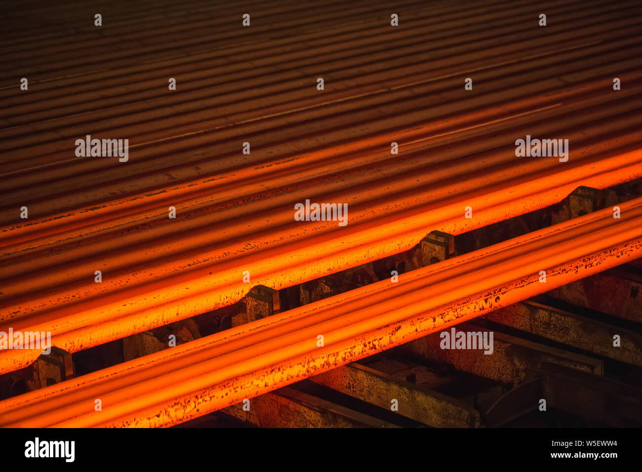 Hot square steel bloom on the roll. Huge ironworks Stock Photo - Alamy