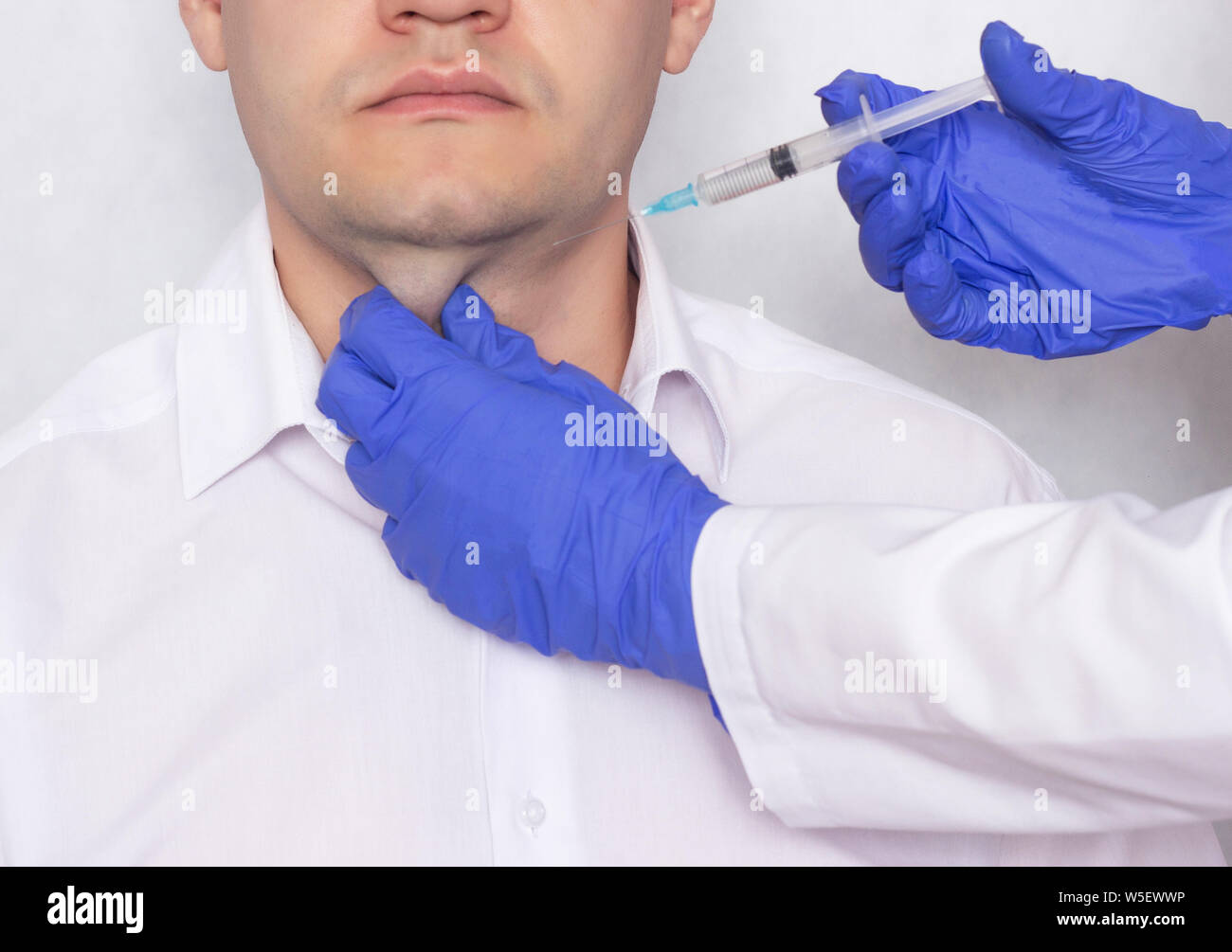 The doctor makes the patient in a double chin lipolitic injection ...