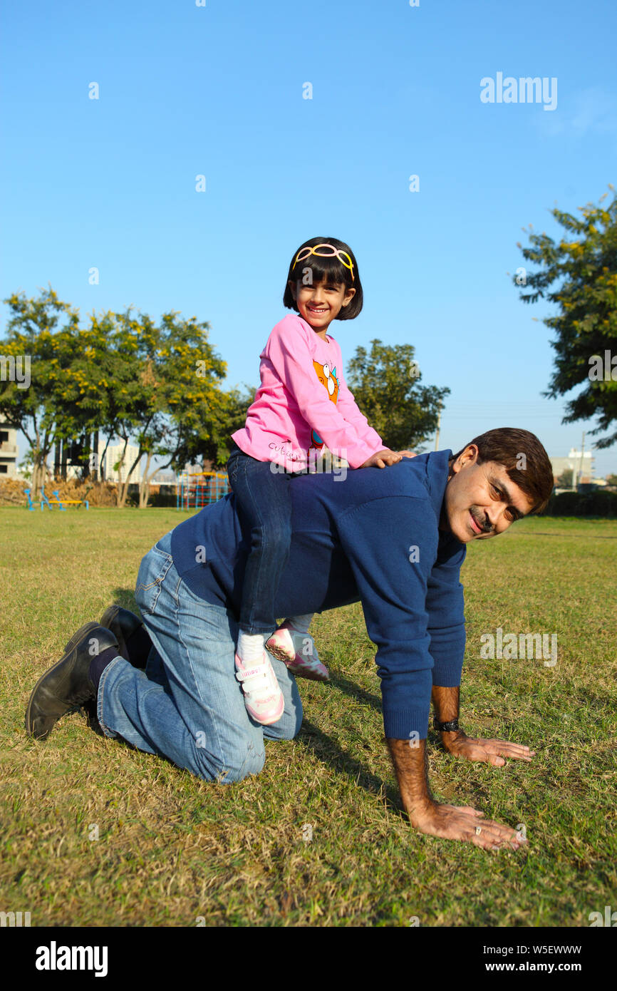 Old man crawling with granddaughter on back in a park Stock Photo - Alamy