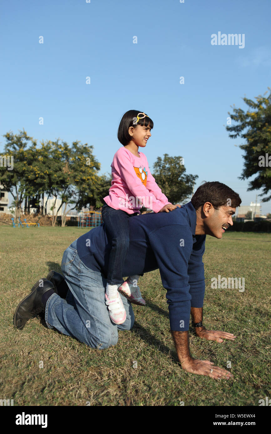 Old man crawling with granddaughter on back in a park Stock Photo - Alamy