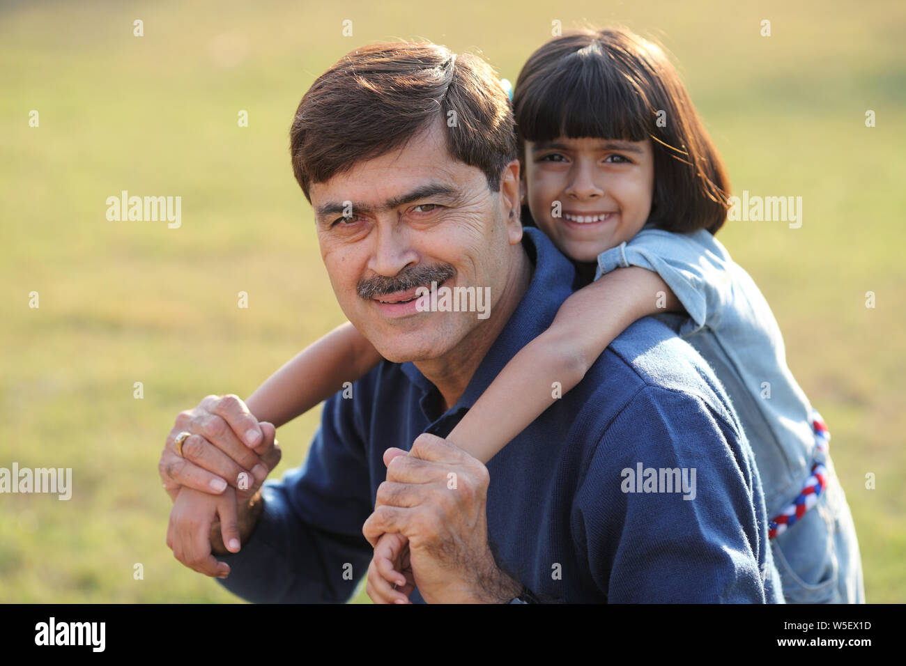 Old man giving piggyback to his granddaughter Stock Photo - Alamy