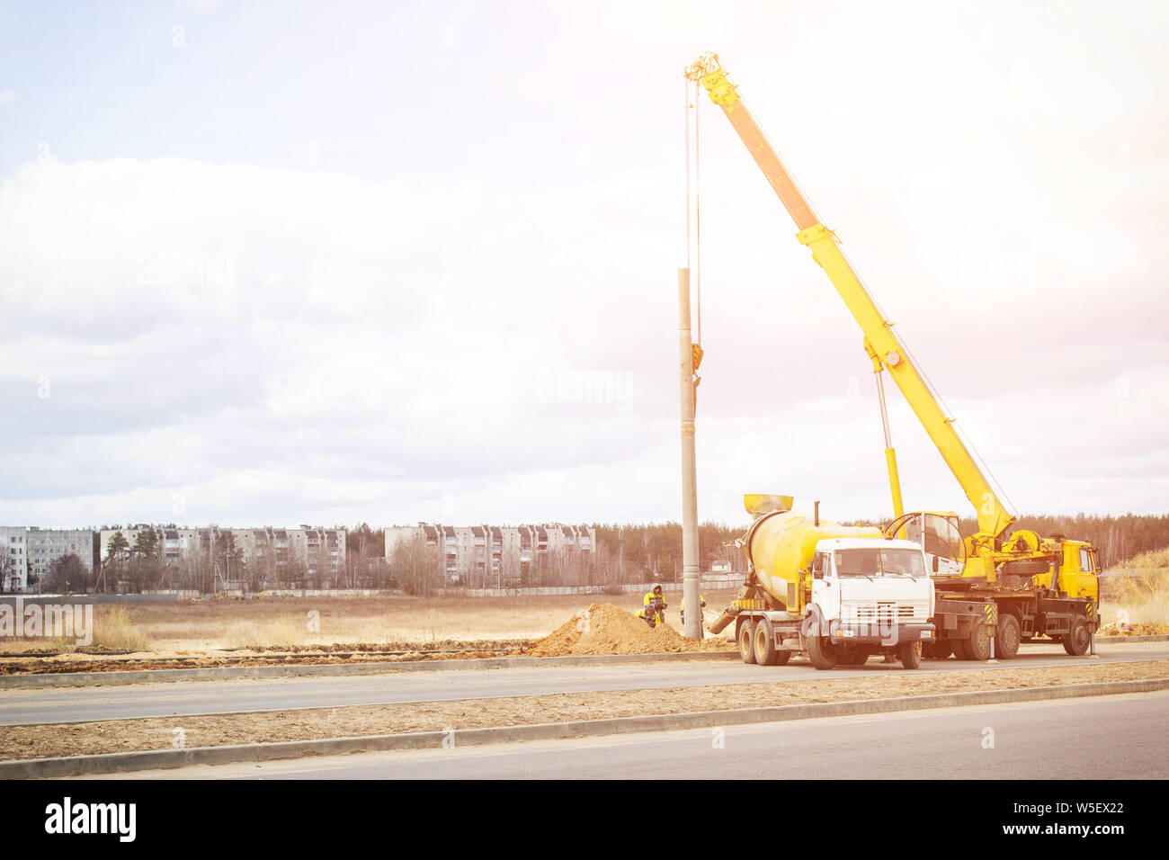 Construction of a new road and installation of lampposts using a truck ...
