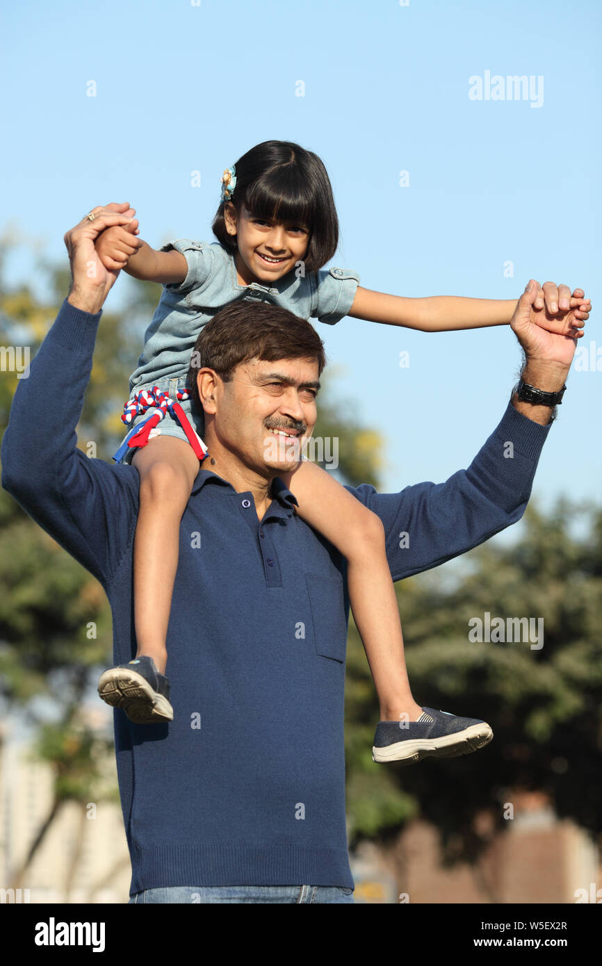 Old man carrying his granddaughter on his shoulders and smiling Stock ...
