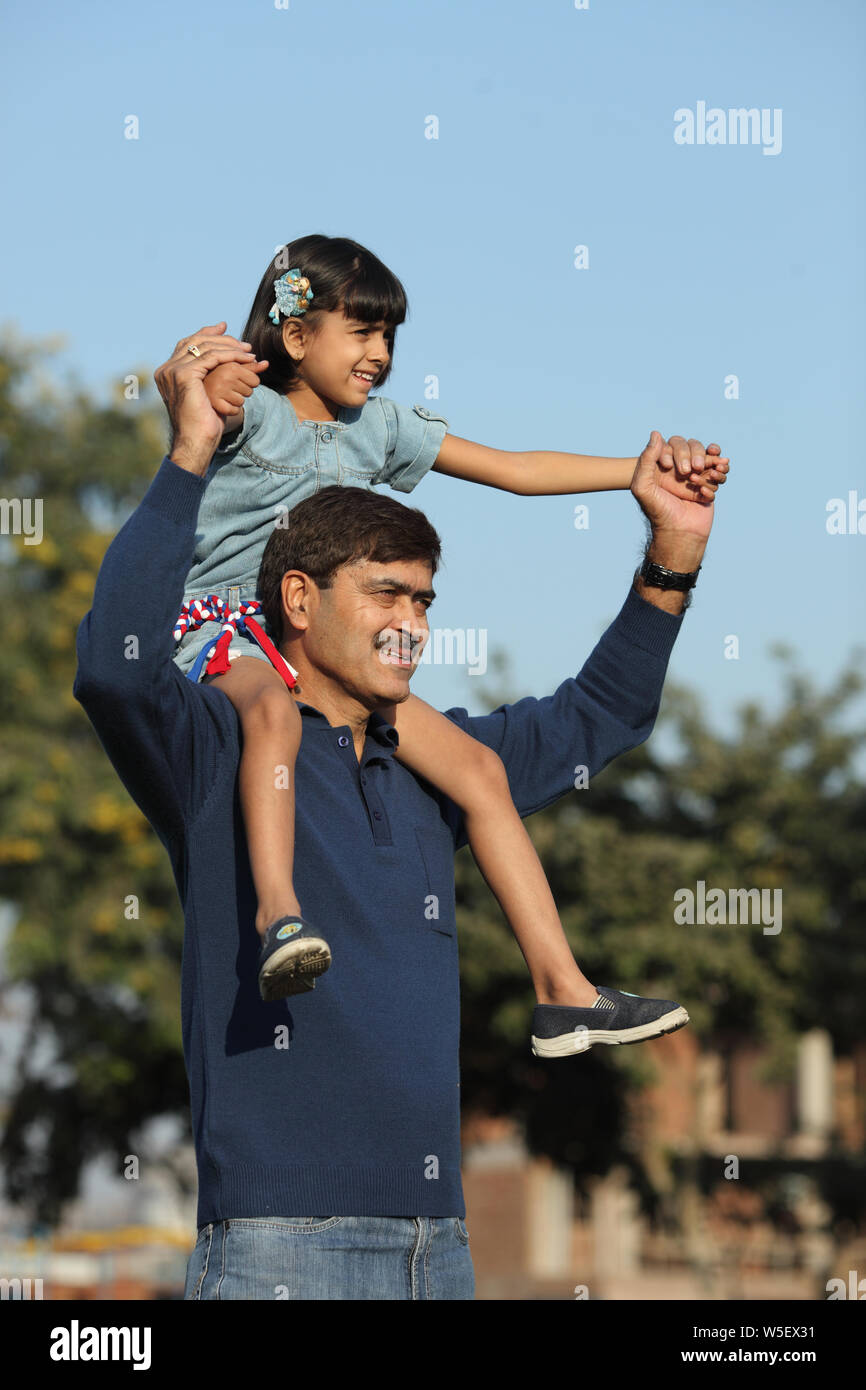 Old man carrying his granddaughter on his shoulders and smiling Stock ...