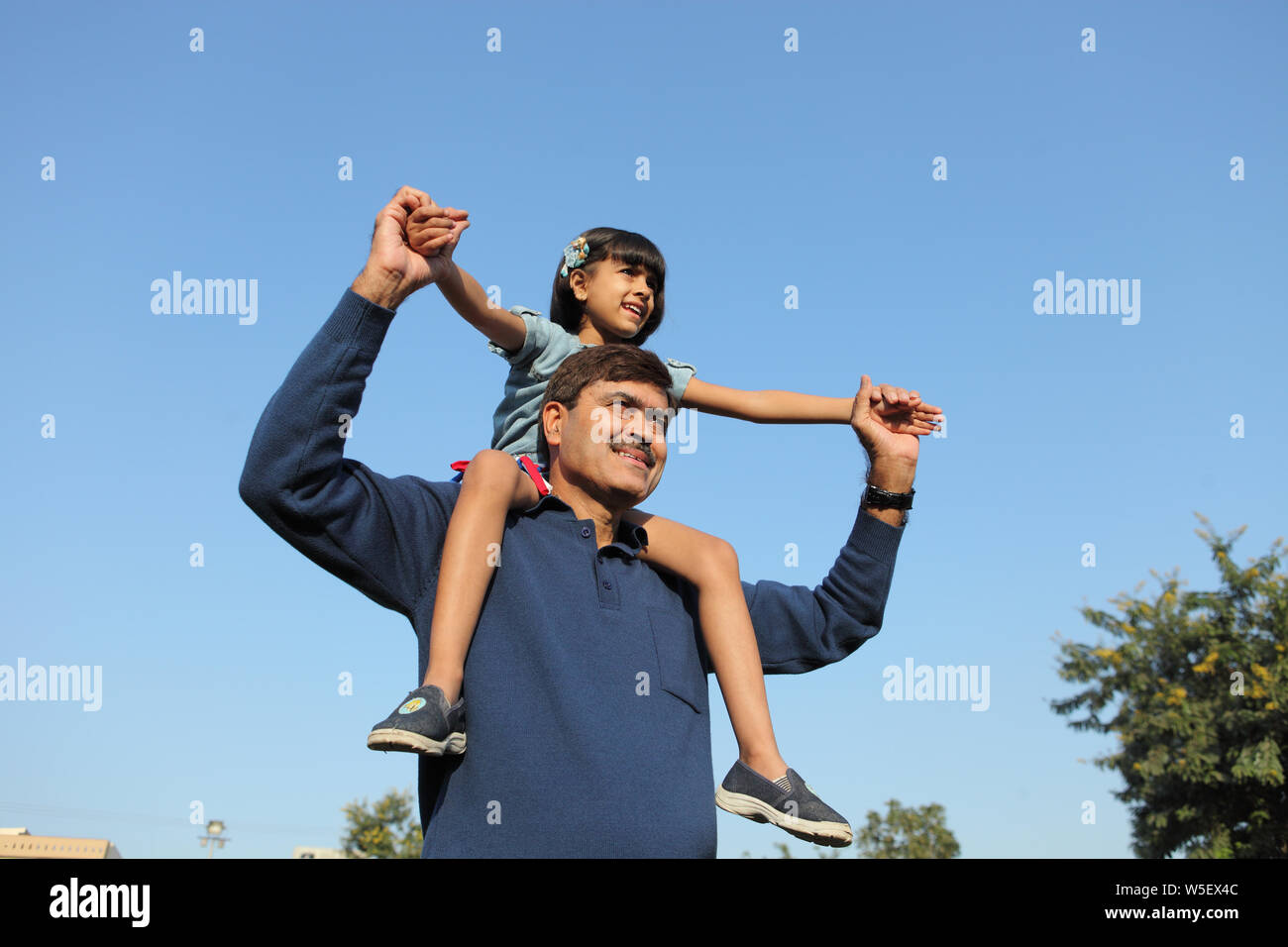 Old man carrying his granddaughter on his shoulders Stock Photo - Alamy
