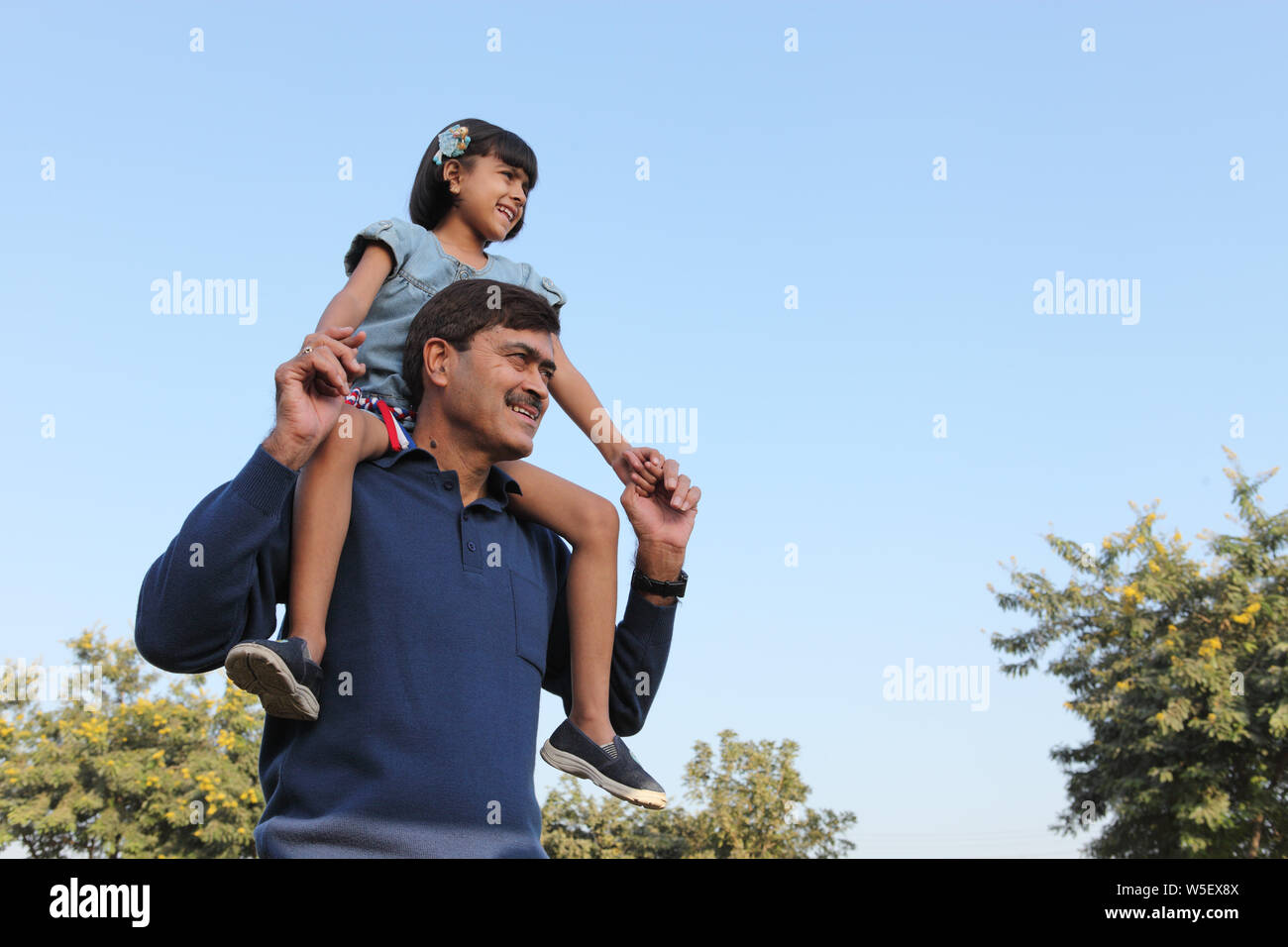 Old man carrying his granddaughter on his shoulders Stock Photo - Alamy