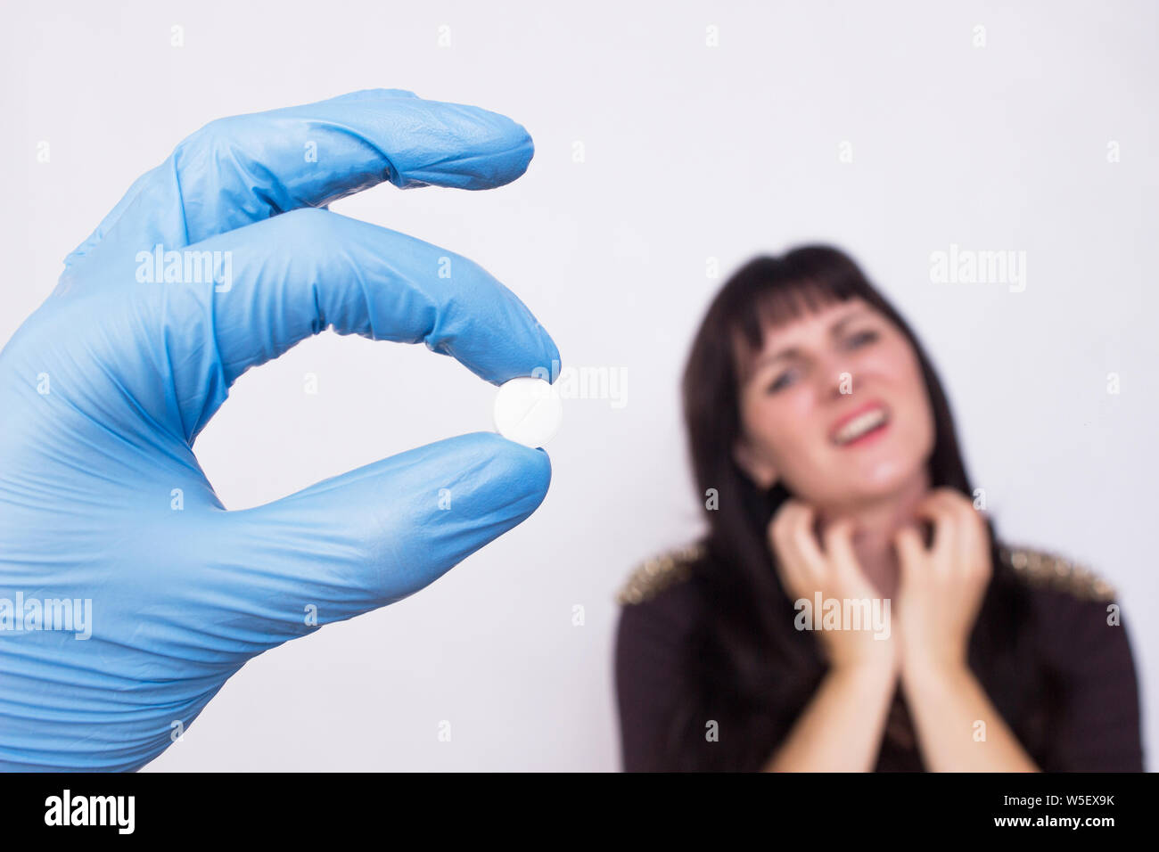 Doctor holds a pill in her hand against scabies and skin irritation ...