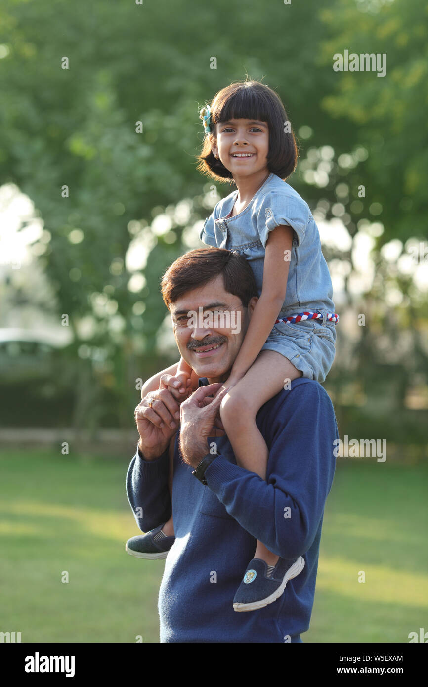 Old man carrying his granddaughter on his shoulders Stock Photo - Alamy