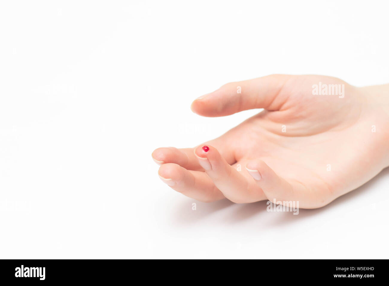 Female hand on white background and blood from a finger concept of a ...