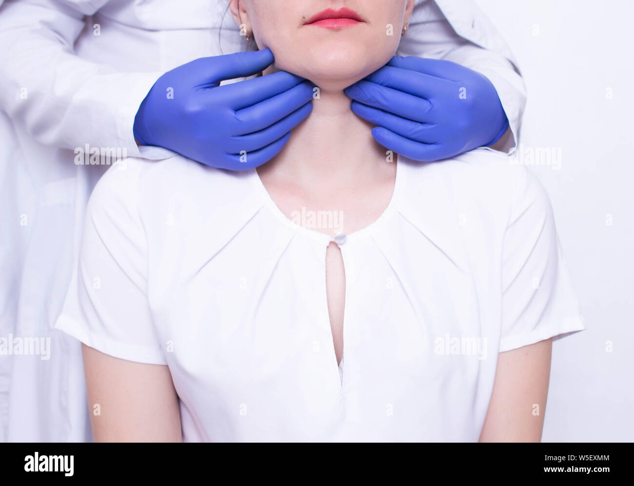 Doctor specialist diagnoses palpation on the throat of the caucasian ...