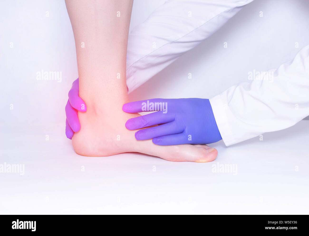 The doctor conducts a medical examination of the patient's ankle joint ...