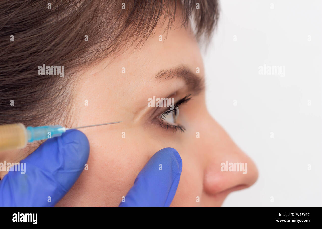 A doctor makes a plasma-lifting shot in a scar on a girl's face for ...