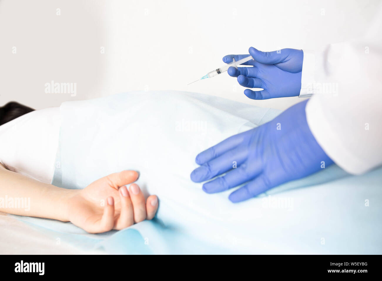 Doctor proctologist treats a patient for hemorrhoids with the help of ...