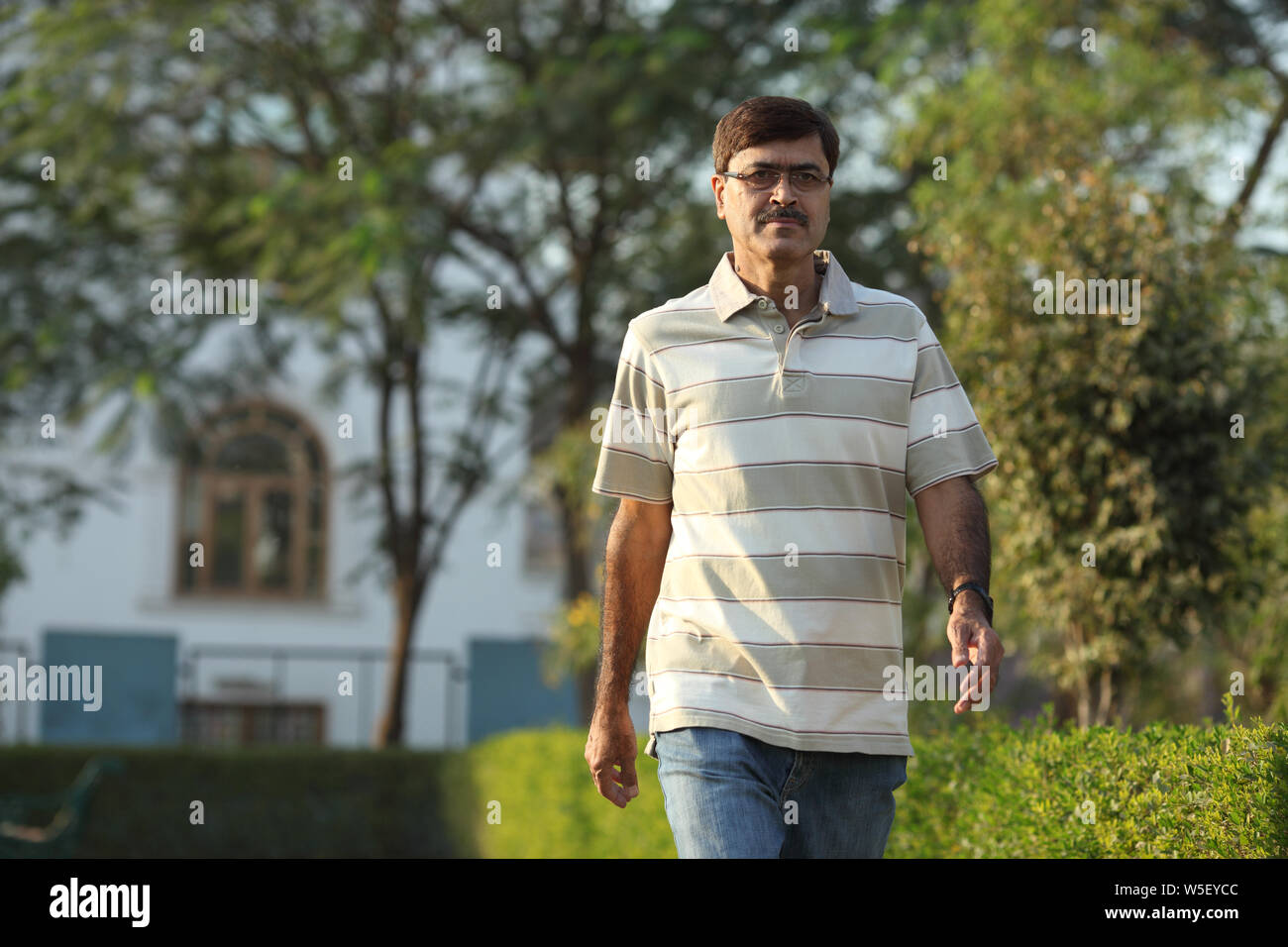 Man walking in a park Stock Photo - Alamy