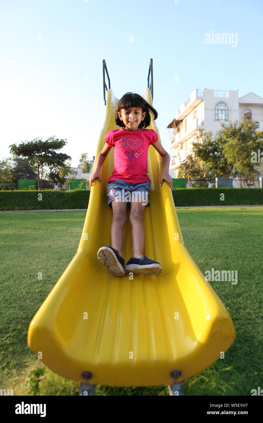 Girl on a slide and smiling Stock Photo - Alamy