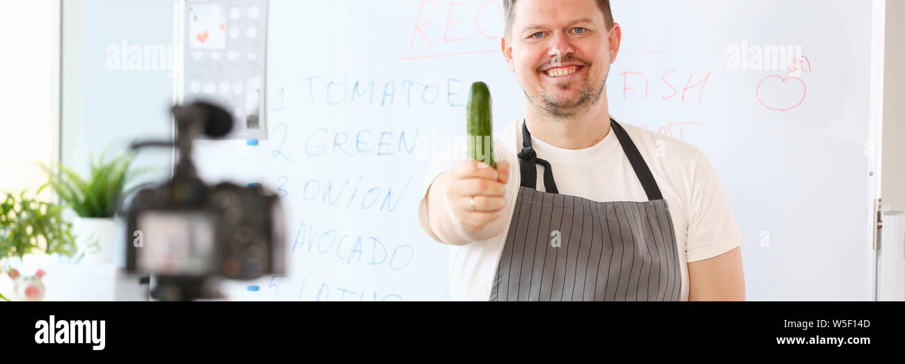 Smiling Vlogger Chef Recording Green Cucumber Stock Photo - Alamy