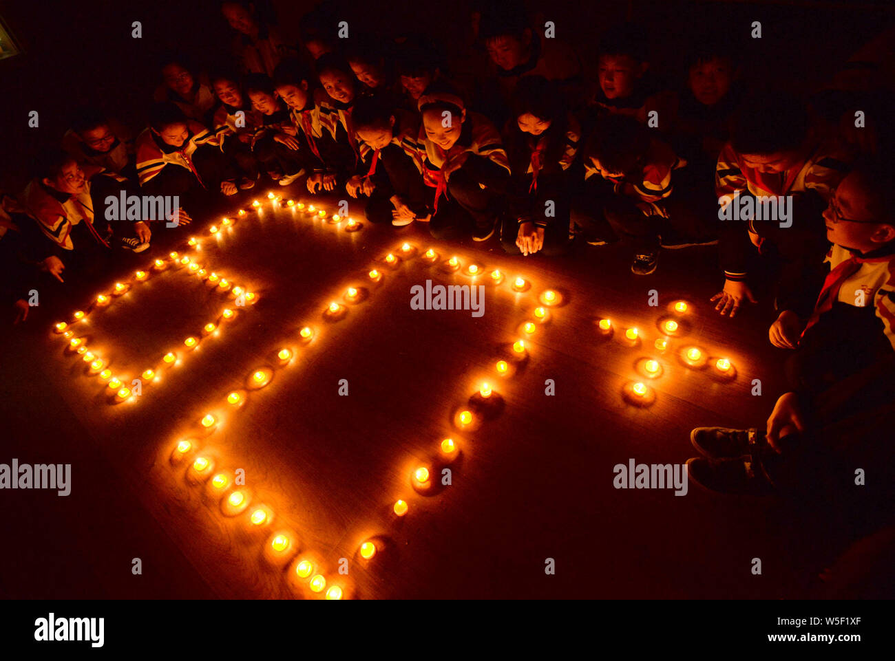 Students light candles to mark the Earth Hour, inspiring people to take ...